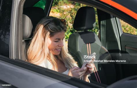 부조종사 좌석에 앉아 있는 금발 여자는 차에서 스마트폰을 사용한다 로드 트립 기술 교통수단에 대한 스톡 사진 및 기타 이미지