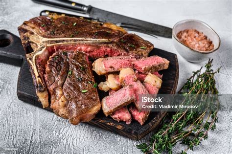 나무 도마에 슬라이스 구운 T뼈 쇠고기 고기 스테이크 흰색 배경입니다 위쪽 보기 Steakhouse에 대한 스톡 사진 및 기타 이미지 Steakhouse 검은색 고기
