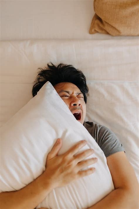 Sleepy Man Keep On Sleeping On The Bed Using Pillow Covering His Face