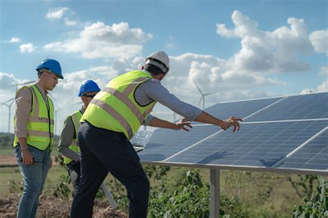엔지니어 는 전자 장치로 태양 전지 패널 또는 태양광 전지의 건설을 검사합니다 녹색 전력의 산업 재생 에너지 타워 지붕에서 일하는 공장 노동자 3 명에 대한 스톡 사진 및