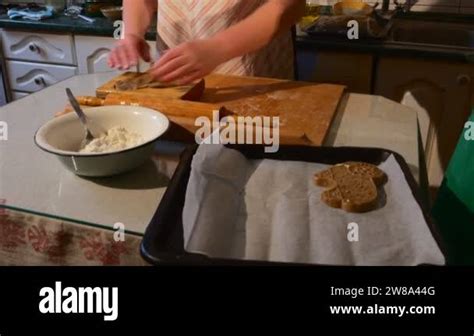 Woman Is Pressing A Dough Into A Ram Shaped Form Cookie On A Baking Tray Husband Is Green Apron