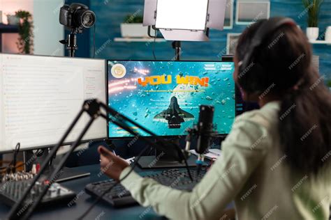 라이브 스트리밍 중에 마이크를 사용하여 플레이어와 이야기하는 우주 슈팅 비디오 게임 경쟁에서 우승한 게이머 여성 Rgb