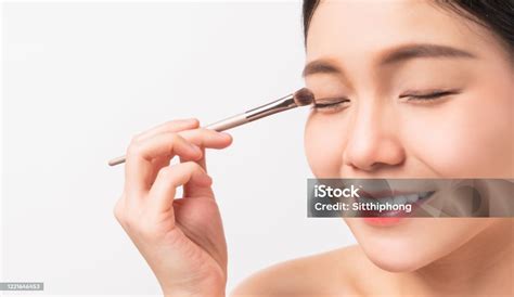 얼굴에 메이크업 파우더 브러쉬를 손으로 들고 웃는 아시아 여성의 뷰티 샷 완벽한 피부의 화장품 갈색 머리에 대한 스톡 사진 및 기타 이미지 Istock