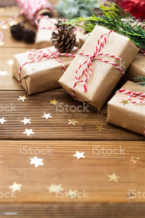 크리스마스 모형 공예 용지 전나무 가지 빨간 Baubles 나무 테이블 위에 소나무 콘 축제 휴가 시즌에 싸여 선물 상자 공간을 복사합니다 배경 주제에 대한 스톡 사진 및