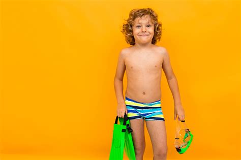 노란 배경에서 고립된 수영을 위한 지느러미와 고글을 가진 수영복을 입은 곱슬 머리를 가진 어린 소년 노란색 배경에 대한 스톡 사진 및 기타 이미지 Istock