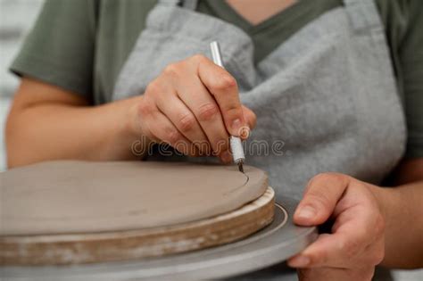 Girl Is Modeling Clay Into A Round Form Using A Sharp Pottery Carving Knife To Cut Out A