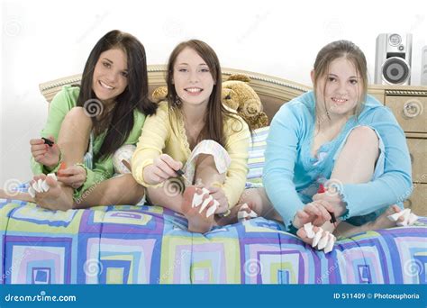 Slumber Party Young Women Together At Home Lying On Bed Looking Camera