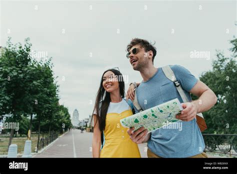 Handsome Man Holding Map And Asian Woman Looking Away Stock Photo Alamy
