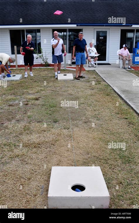Senior Retired Citizens Play Game Of Bean Bag Toss In A Recreational Vehicle Camping Park In