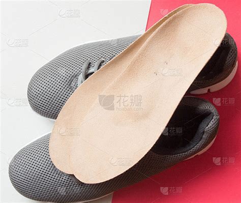 红白背景的骨科鞋垫和运动鞋。预防骨科足病，足部护理。