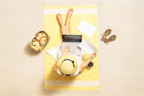 사업가 프리랜서는 모래 해변의 비치 타월에 앉아 그래픽과 차트와 노트북에서 작업 커피를 마시고 여름 방학 공중 보기 35 39