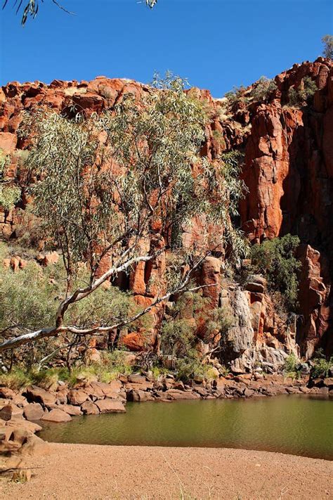Steep Rocky Cliff With Green Water At Python Pool In Western Australia