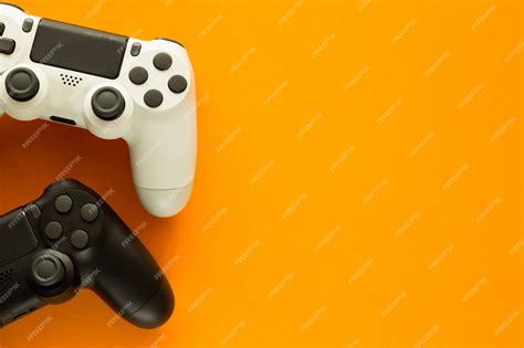 Premium Photo Two Gamepads On A Yellow Table And Copy Space