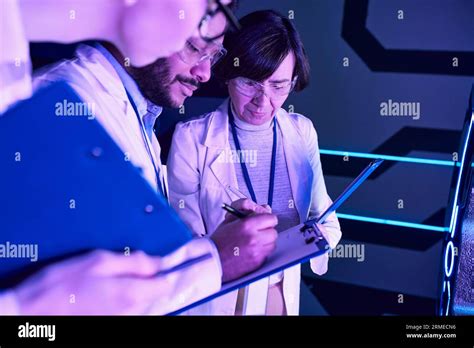 Futuristic Documentation Three Scientists Record Parameters In Neon