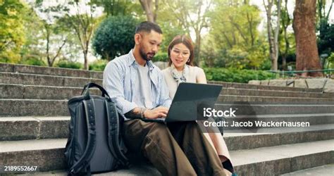 커플 노트북 공원 여행 또는 계단에서 독서를 하며 방향 휴가 및 계획을 검색합니다 남자 여자 Pc 가방 타이핑에 만족하여 일본 호텔 예약 알림을 확인합니다 25 29세에