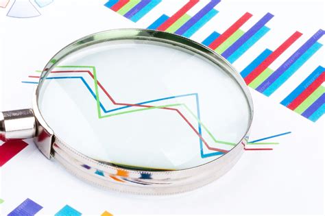 Premium Photo Magnifying Glass Lying On Business Charts And Graphs