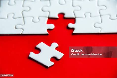 빨간색 표지 배경에 나머지와 분리된 흰색 직소 퍼즐로 텍스트 또는 아이디어를 위한 사용자 지정 가능한 공간이 있습니다 공간을 복사합니다 0명에 대한 스톡 사진 및 기타