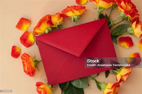 중립 베이지 색 배경에 우편 빨간 봉투에 아름다운 빨간 장미 꽃 텍스트를위한 복사 공간 봄 시간 휴가를위한 인사말 카드 꽃 배달 섬세한 붉은 노란 장미 최소한의 트렌디 한