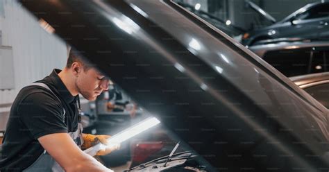 후드 아래 제복을 입은 남자가 자동차 서비스에서 일하고 있습니다 사진 Unsplash의 자동차 이미지