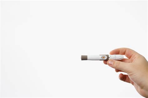 흰색 배경에 혈당 측정기로 혈당 수치를 확인하기 위해 란셋을 들고 있는 인간의 손 신체 부위 사진 가지 식물 부위에 대한 스톡 사진 및 기타 이미지 Istock