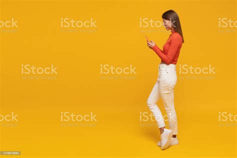 노란색 복사 공간 배경에 서있는 여성의 측면보기 전화를 사용하여 온라인 채팅 여자에 대한 스톡 사진 및 기타 이미지 여자 사람들 한 사람 Istock