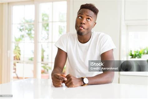 집에서 흰색 테이블에 잘생긴 아프리카계 미국인 남자 입술 미친 및 코믹 제스처와 물고기 얼굴을 만들기 재미 있는 표현 만들기에 대한 스톡 사진 및 기타 이미지 Istock