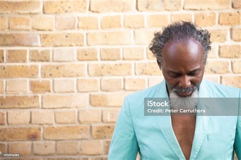 벽돌 벽 옆에 있는 청록색 재킷을 입은 성숙한 남자의 초상화 55 59세에 대한 스톡 사진 및 기타 이미지 55 59세 개성 개념 괴짜 Istock