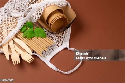 크래프트 종이 식품 컵과 복사 공간이있는 갈색 배경에 흰색 면 그물 가방에 나무 칼붙이 용기 친환경 식기 길거리 음식은 종이 포장을 빼앗습니다 0명에 대한 스톡 사진 및