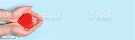 파란 배경에 고립 된 사람의 손에 빨간 마음 의료 및 병원 의료 개념 발렌타인 데이의 상징 텍스트 공간이 있는 상단 보기입니다 배너 Donors Choose에 대한 스톡