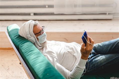 Premium Photo Senior Man With Medical Mask On Face Using Smartphone