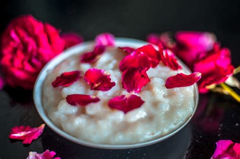 인기 있는 인도 및 아시아 라마단 요리 또는 라마잔 디저트 즉 유리 접시에 장미 꽃과 꽃잎과 함께 Kheer Eid Ul