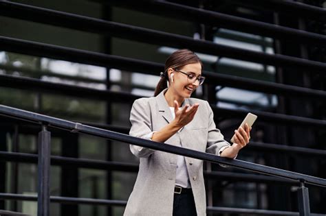 야외에 서서 전화를 통해 화상 통화를하는 행복한 젊은 사업가 휴식 시간에 화상 통화에 사업가 Brand Name Smart Phone에 대한 스톡 사진 및 기타 이미지