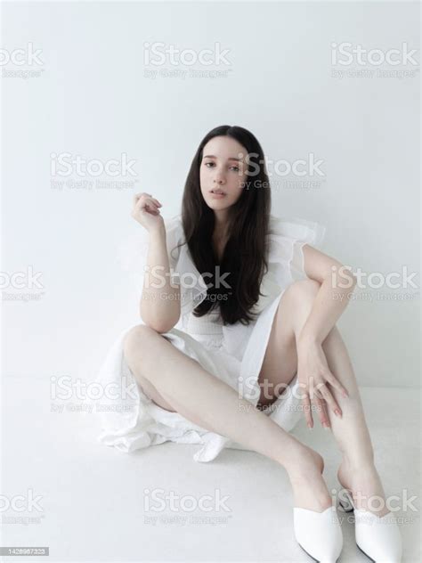 몽환적인 흰색 드레스와 신발로 바닥에 앉아있는 아름다운 젊은 갈색 머리 여자 전체 길이 바디 밝은 배경에 패션 모델 스튜디오 초상화 소녀의 예술적 예쁜 그림 긴 머리 자연