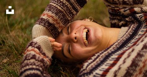 낮 동안 푸른 잔디밭에 누워 있는 갈색과 흰색 스웨터를 입은 여자 사진 Unsplash의 무료 게르 이미지