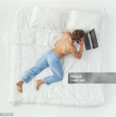 전체 길이한 사람한 사람직접 위의 보기후면뒤 2029 세 성인 잘 생긴 사람 갈색 머리짧은 머리 백인 남성젊은 남자 침실에서 잠 옷잠 옷을 입고 흰색 배경 앞 갈색 머리에