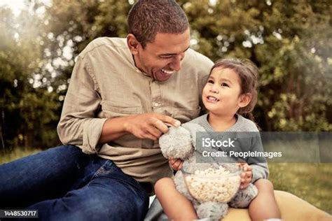 아버지 소녀 팝콘을 먹고 행복한 아이와 부모는 야외에서 웃으며 웃고 있다 아빠 행복 그리고 아이가 음식 포옹과 함께 유대감 양질의 시간 자연 체험을 하며 즐거운 시간을