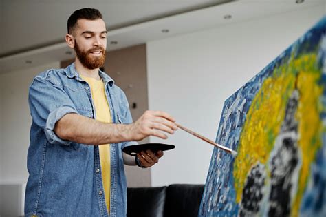 넓은 아트 스튜디오에서 작품을 즐기면서 이젤과 미소에 재능있는 수염 예술가 그림 그림의 초상화 그림 그리기에 대한 스톡 사진 및 기타 이미지 Istock