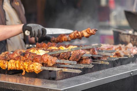 그릴에 길거리 음식 꼬치에 고기 바베큐 배경에는 케밥을 요리하는 칼을 가진 남자의 손이 있습니다 외부 수평 사진 거리에 대한 스톡 사진 및 기타 이미지 Istock