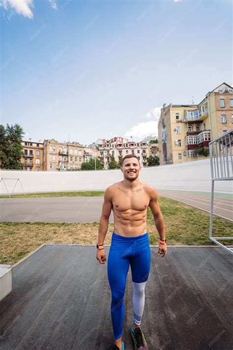 Мускулистый парень позирует на открытом воздухе Бесплатно Фото