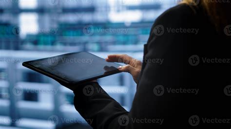 System Administrator Monitoring Server Room Doing Checkup Inputting Data On Tablet Of Needed