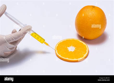 Science Experiment With Orange And Syringe Isolated On White Stock