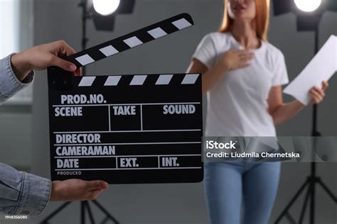 캐스팅 콜 스튜디오에서 회색 배경에 클래퍼 보드를 들고 두 번째 지원 카메라를 수행하는 동안 젊은 여성 근접 촬영 낚싯줄을 던지기에 대한 스톡 사진 및 기타 이미지 Istock