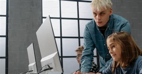 학교 교실에서 컴퓨터를 사용하는 교사의 도움으로 학교 아이들 사진 Unsplash의 앉아 이미지