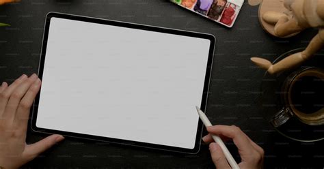 페인팅 도구가 있는 작업대에 스타일러스 펜이 있는 모형 태블릿에 그림을 그리는 여성 디자이너의 상위 뷰 사진 Unsplash의 태국 이미지