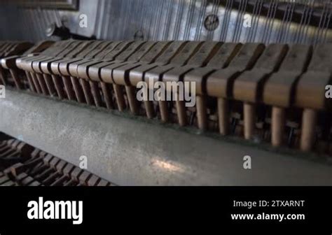 close up dof old demolished dusty piano from the inside hammers striking strings tuned to