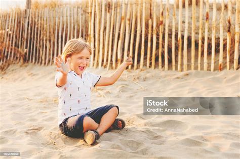 재 밌 보 석양 바다 모래 해변에서 휴식 어린 아이가 즐기는 여름 휴가에 남쪽 프랑스 입고 폴로 데님 반바지와 샌들 신발 금발 머리에 대한 스톡 사진 및 기타 이미지