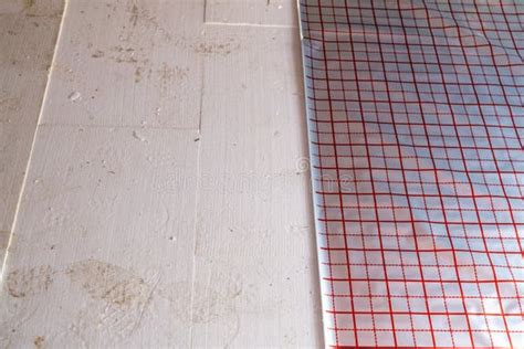 Installing Red Grid Vapor Barrier Film On Insulated Floor During Home