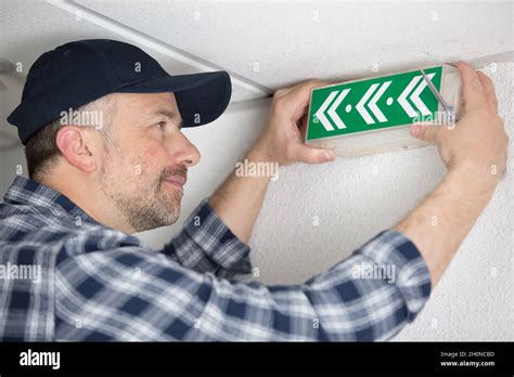 Man Installing An Exit Sign Stock Photo Alamy