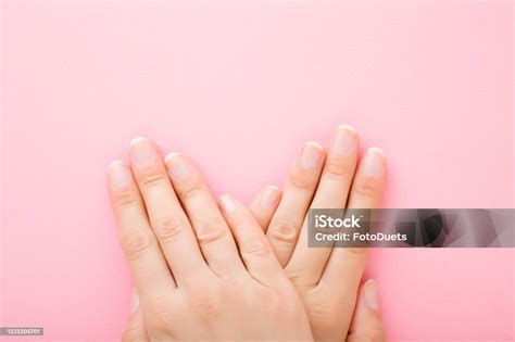 밝은 분홍색 테이블 배경에 매니큐어없이 젊은 여성 손 파스텔 색상입니다 간단한 매니큐어 근접 촬영 텍스트의 빈 장소입니다 하향하 보기 손톱에 대한 스톡 사진 및 기타 이미지