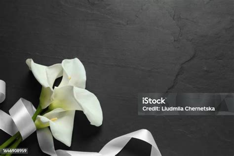 아름다운 칼라 백합 꽃과 검은 테이블에 하얀 리본이 놓여 있고 텍스트를 위한 공간이 평평하게 놓여 있다 장례식 상징 부고에 대한 스톡 사진 및 기타 이미지 Istock